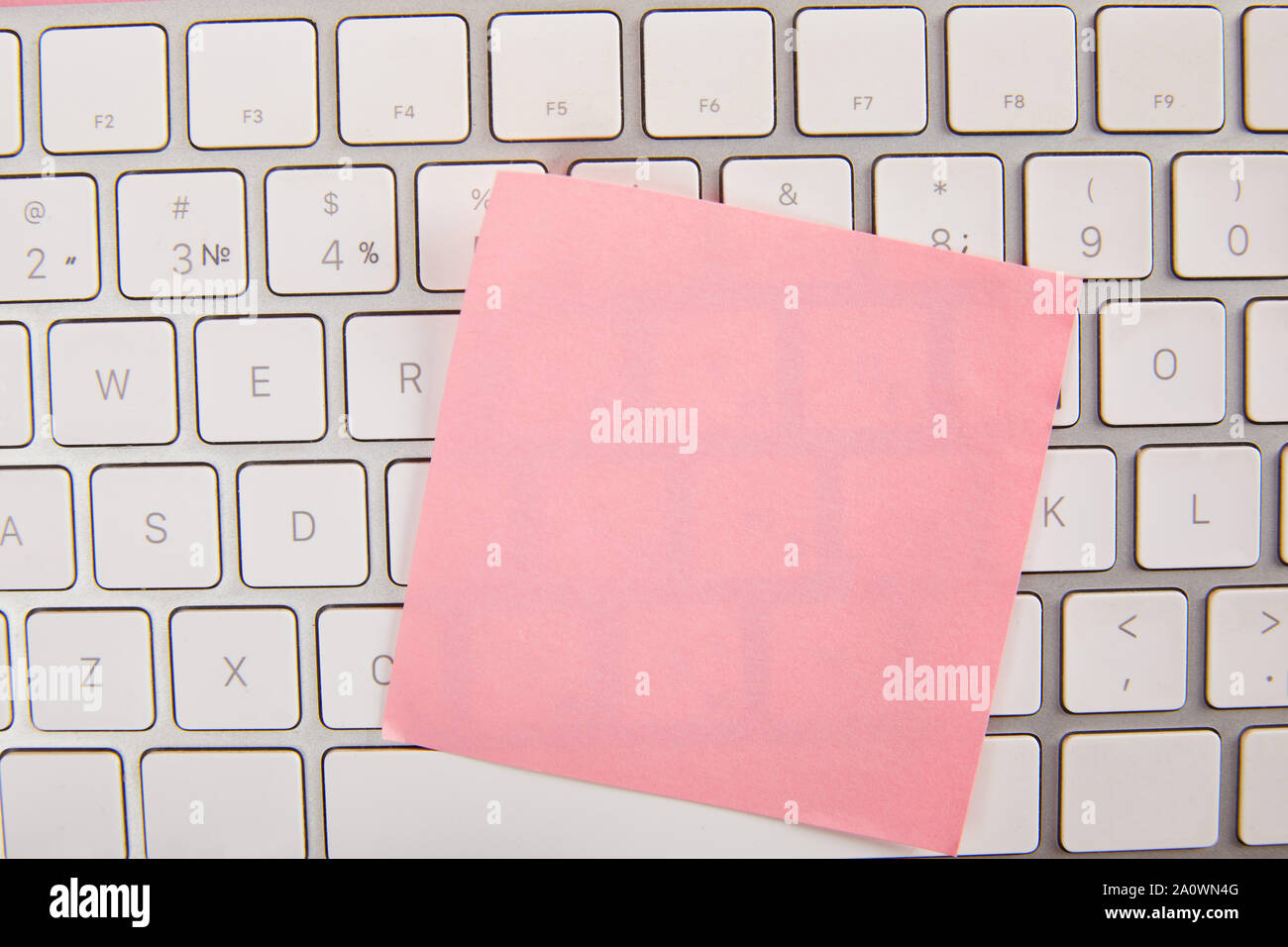 top view of empty pink sticky note on laptop keyboard Stock Photo - Alamy