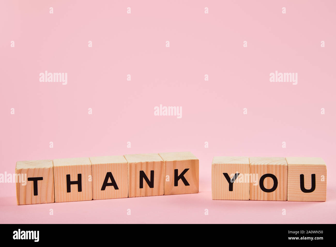 wooden blocks with thank you lettering on pink background with copy ...