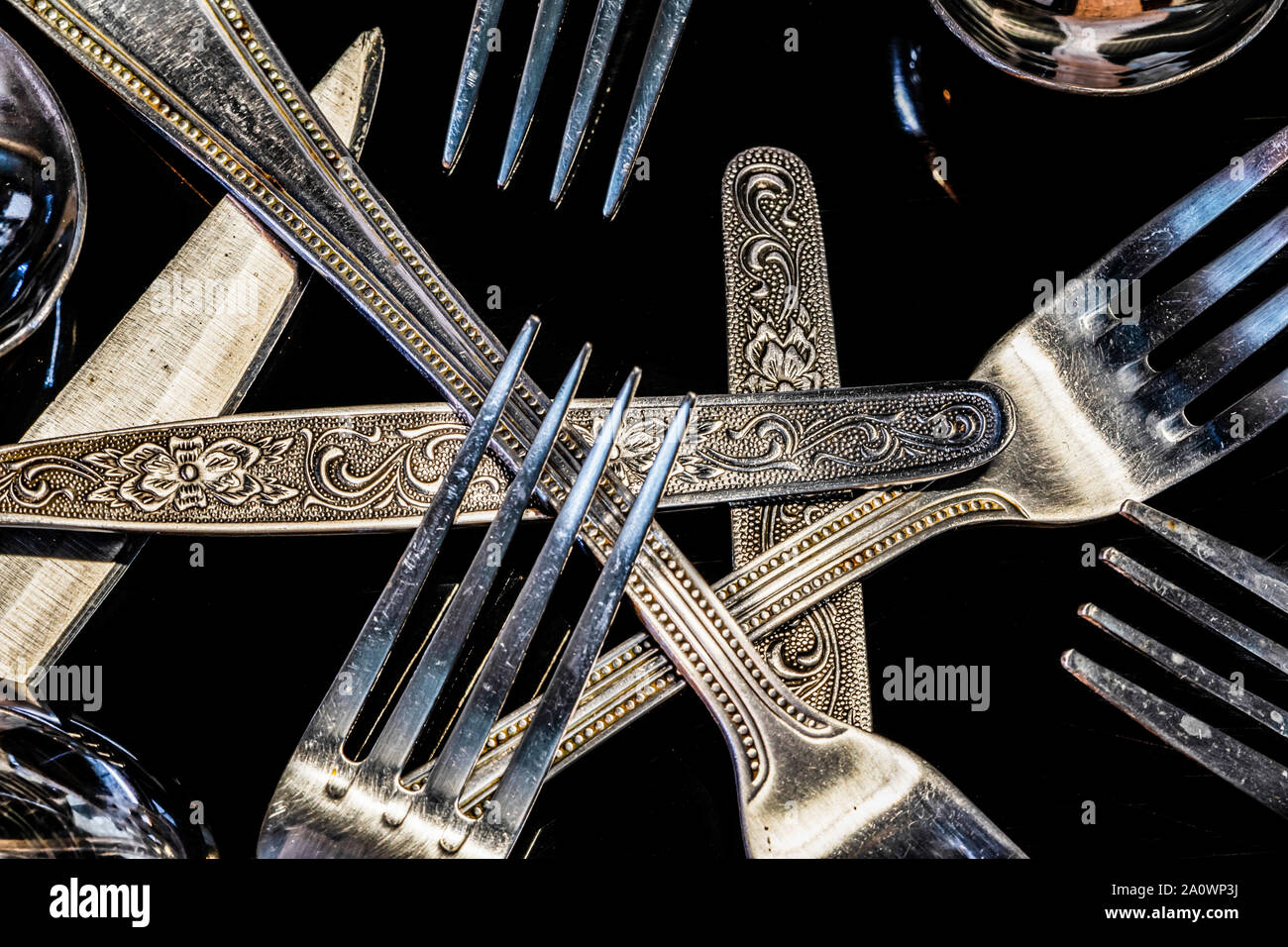 Abstract mix of forks, spoons and knives on a black background Stock ...