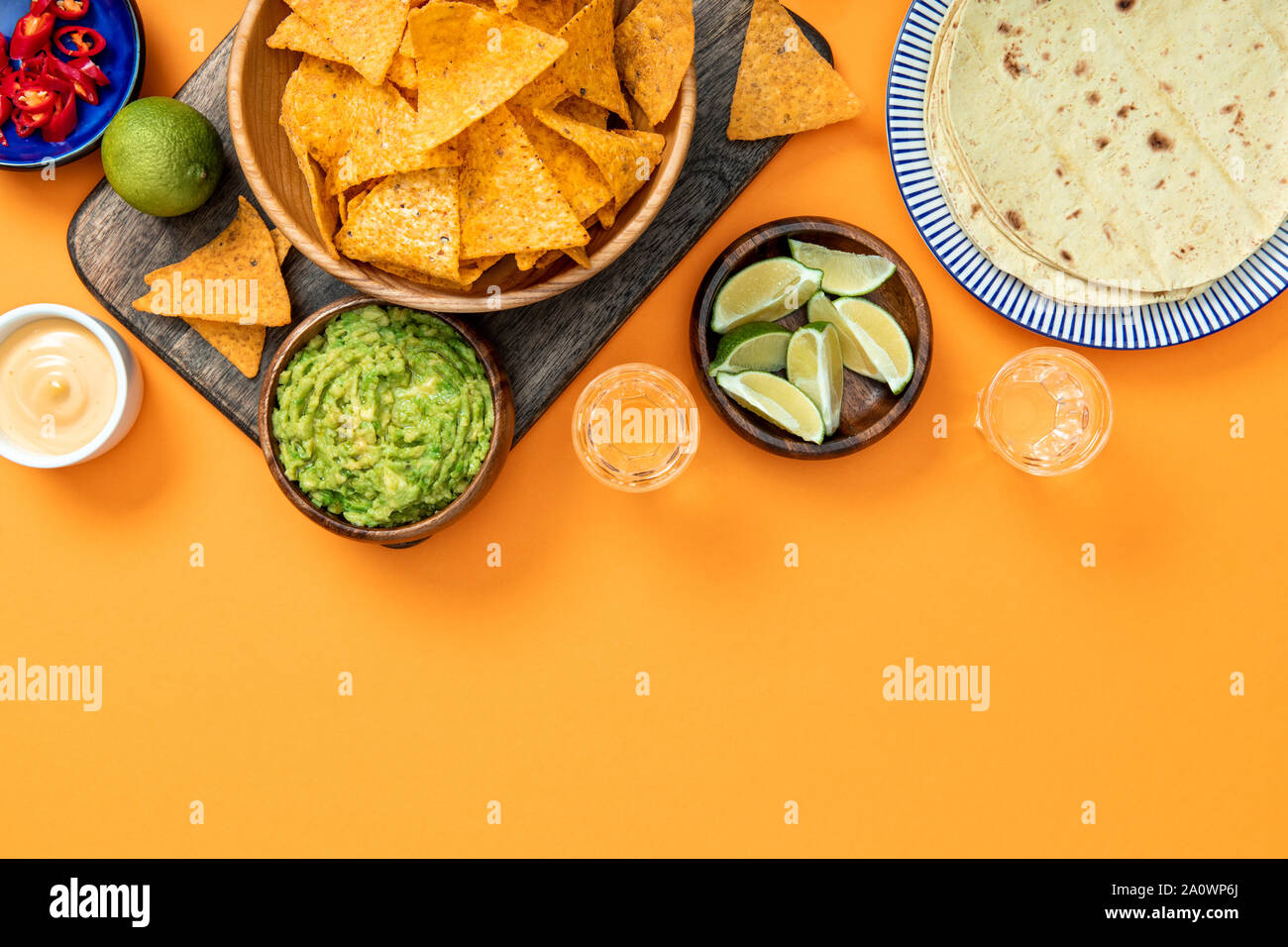 Mexican nachos served on wooden cutting board with guacamole, cheese ...