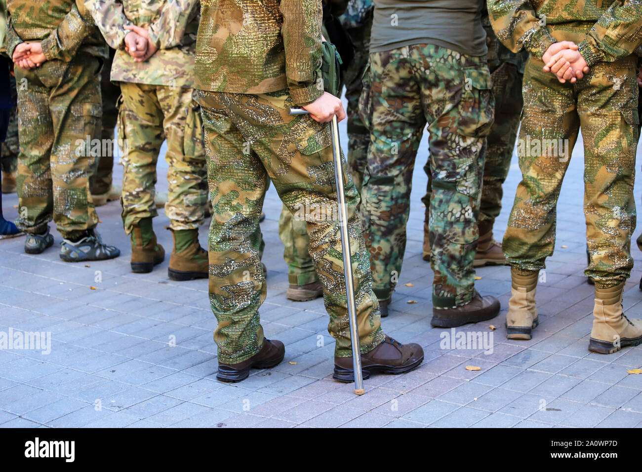 A wounded soldier of the Ukrainian army in uniform stands with a crutch ...