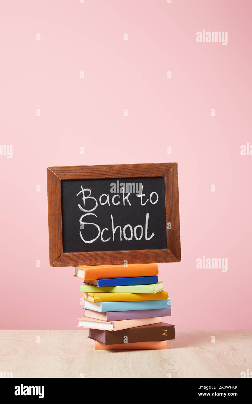 stack of books with chalkboard with back to school lettering isolated ...