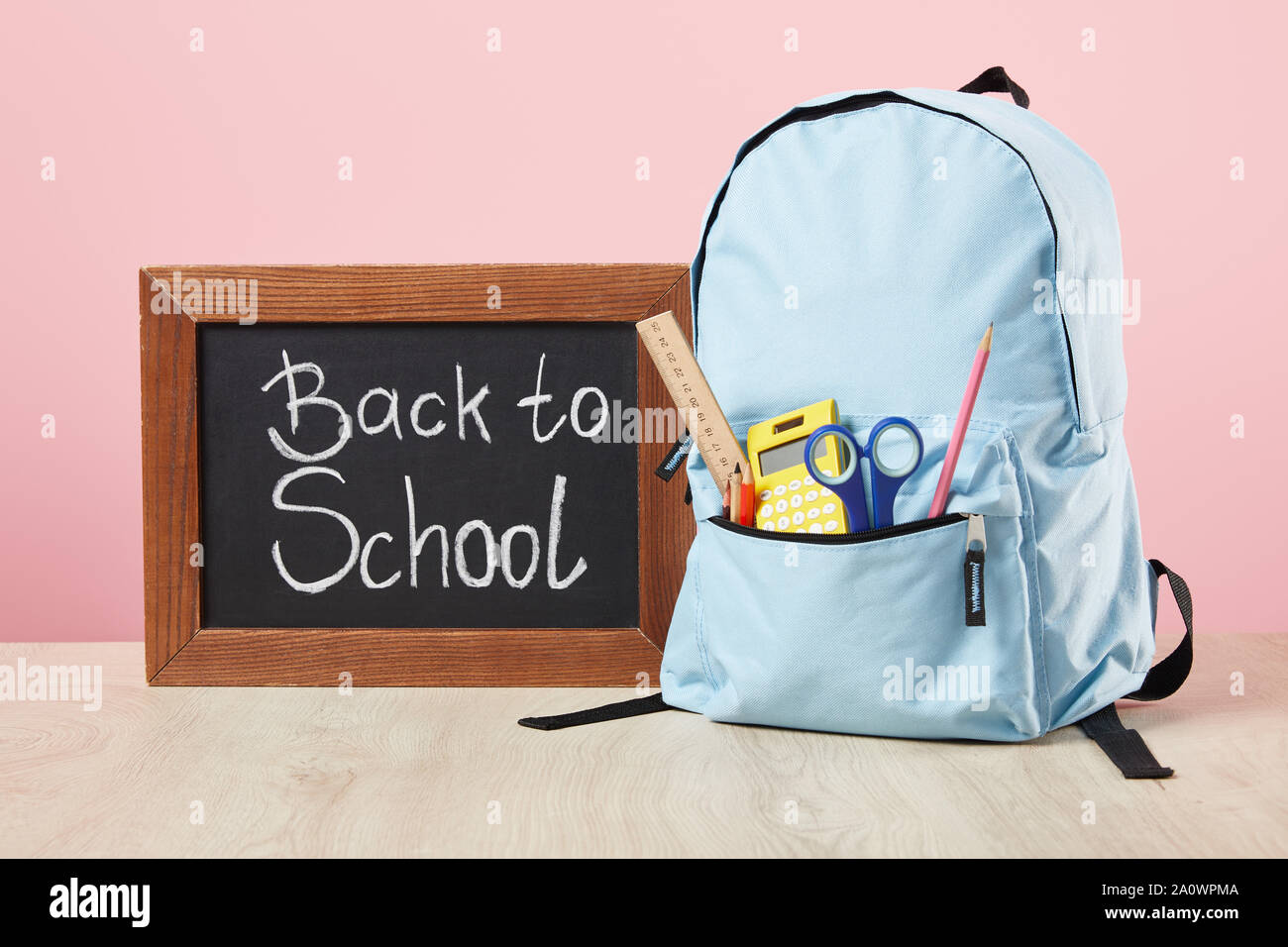 school blue backpack with supplies in pocket near chalkboard with back ...