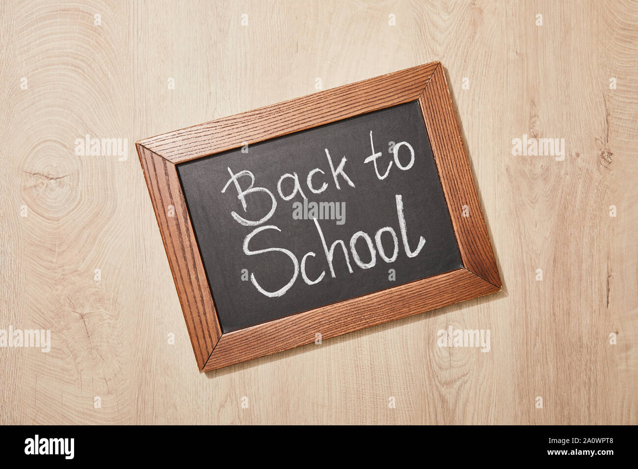 top view of chalkboard with back to school lettering on wooden desk ...
