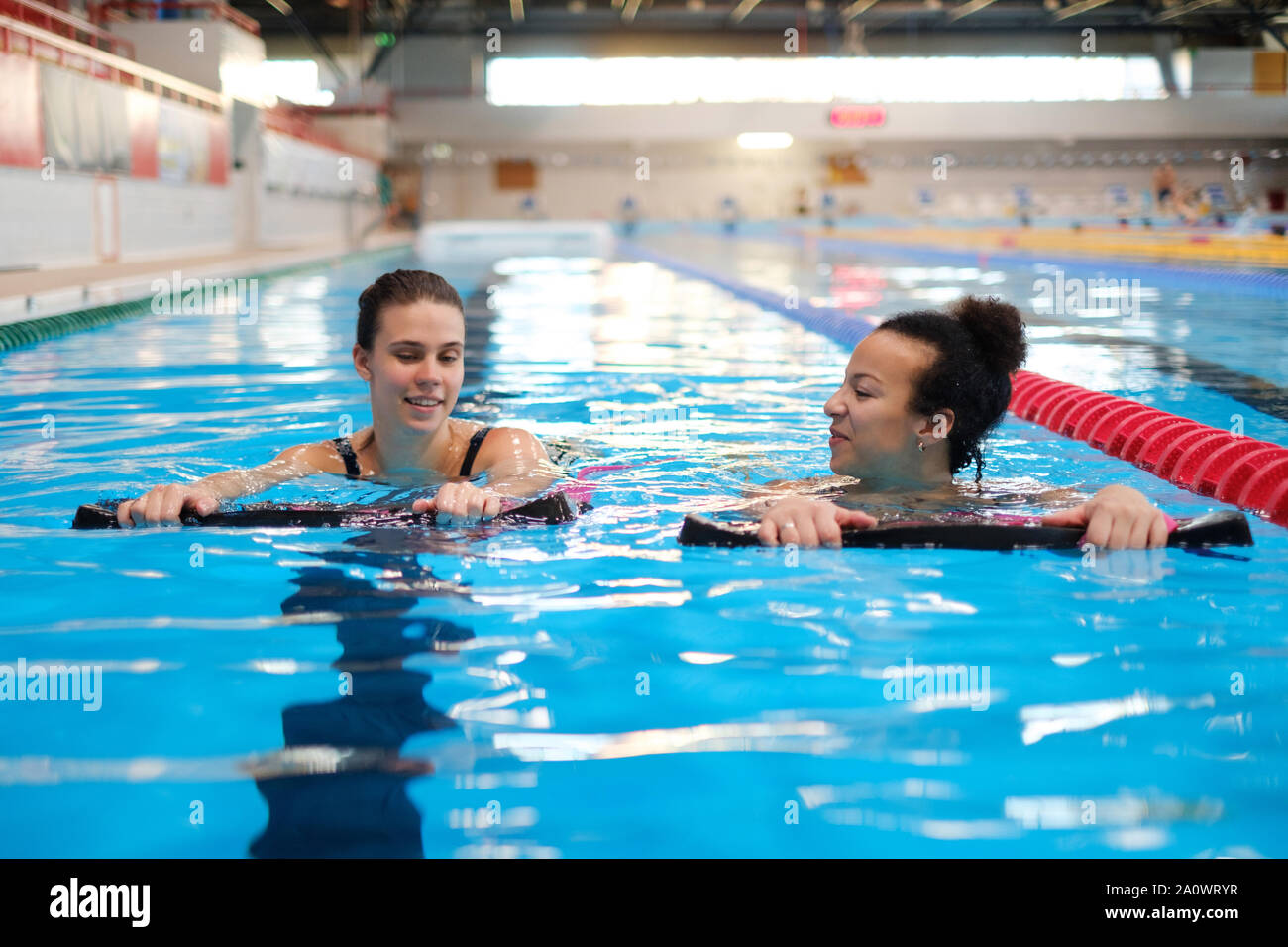 Multiracial couple attending water aerobics class in a swimming pool ...