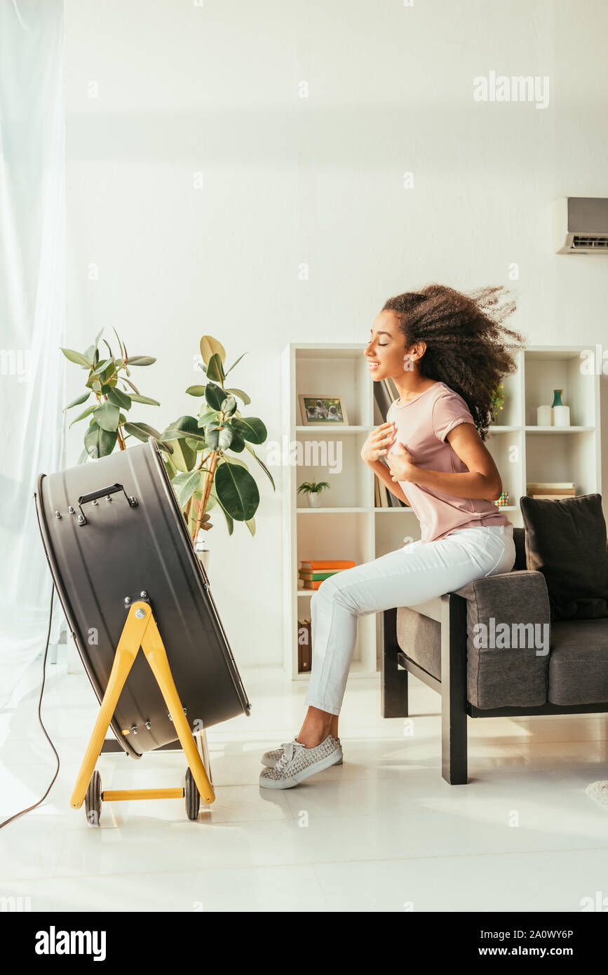 Woman sitting in front of an electric fan hi-res stock photography and ...