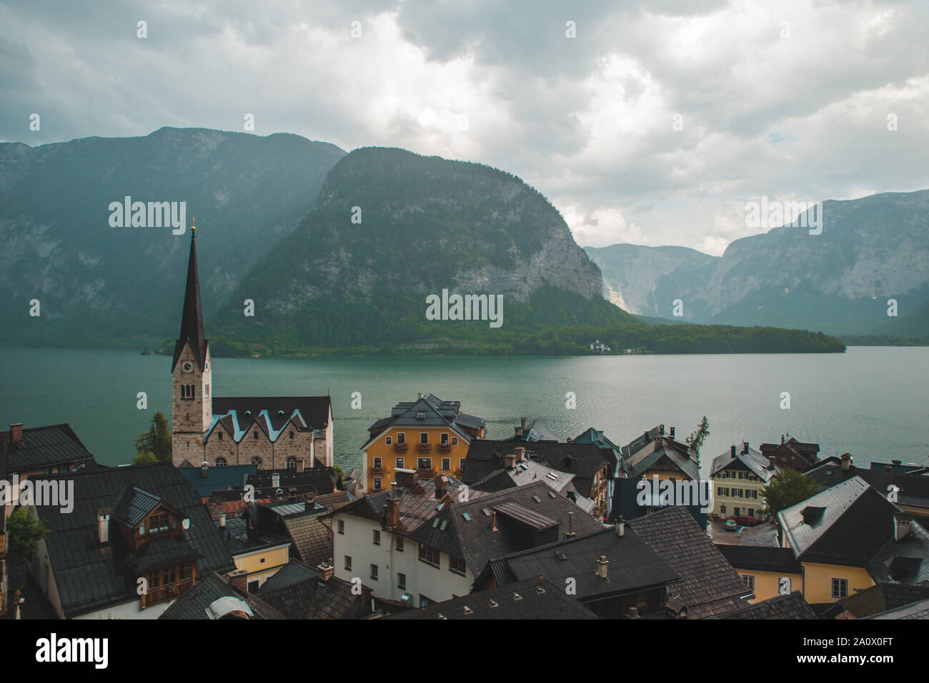 hallstatt church with bell tower lake with alpine mountains on ...