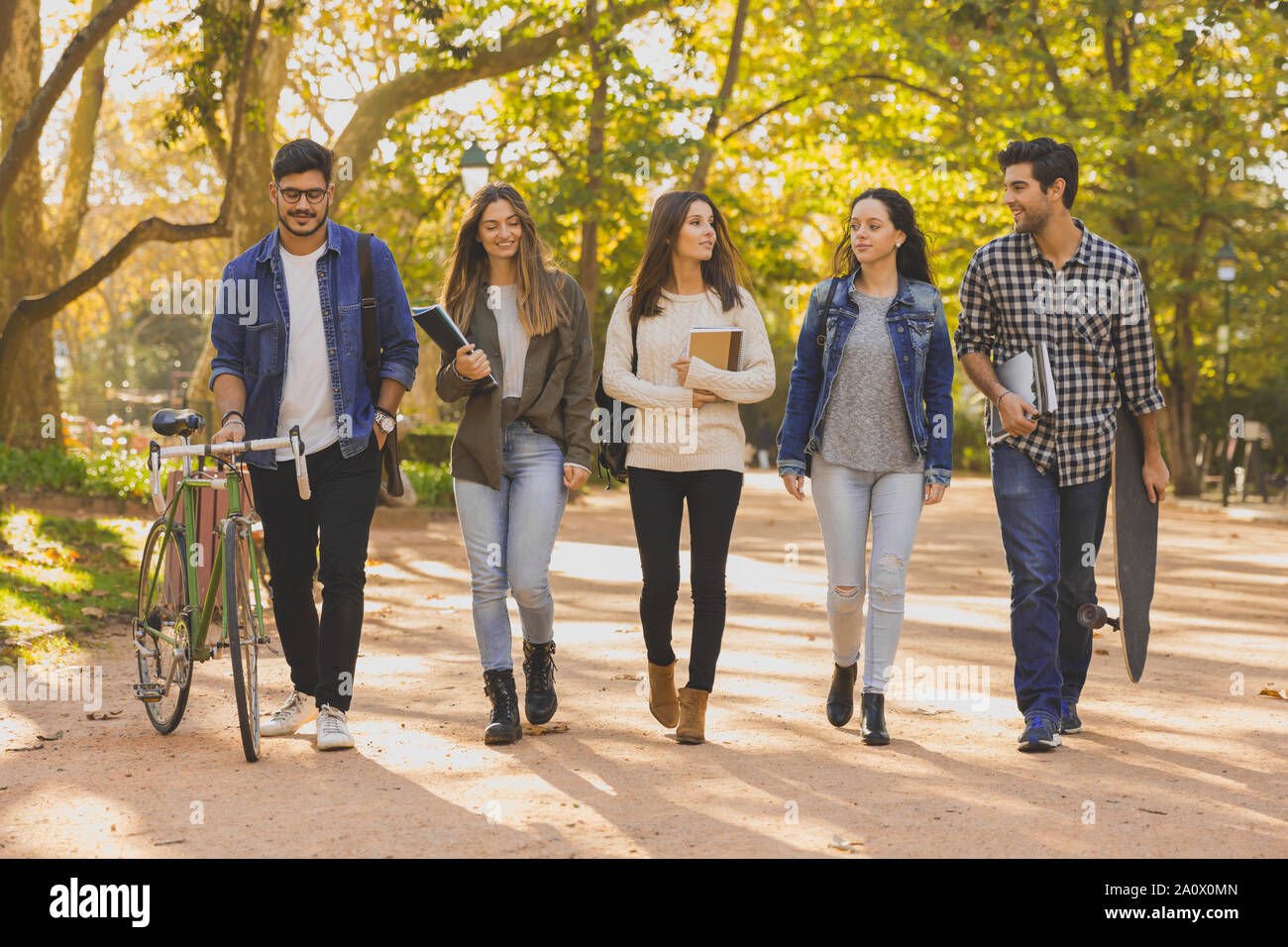 Group of students walking together in the park Stock Photo - Alamy