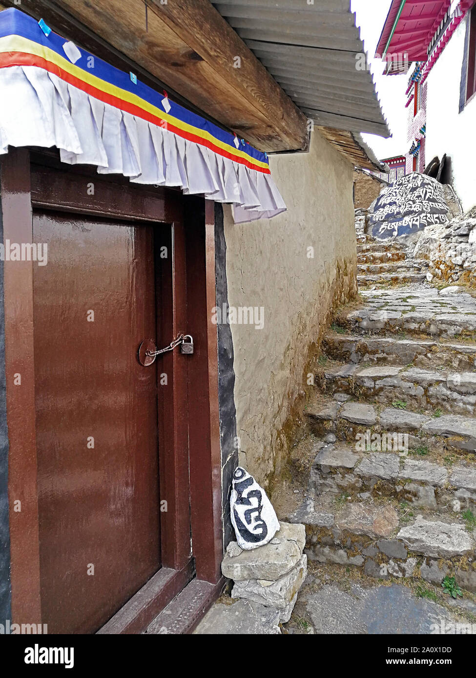 Ancient Buddhist Mani stone with engraved sacred mantra "Om Mani Padme ...