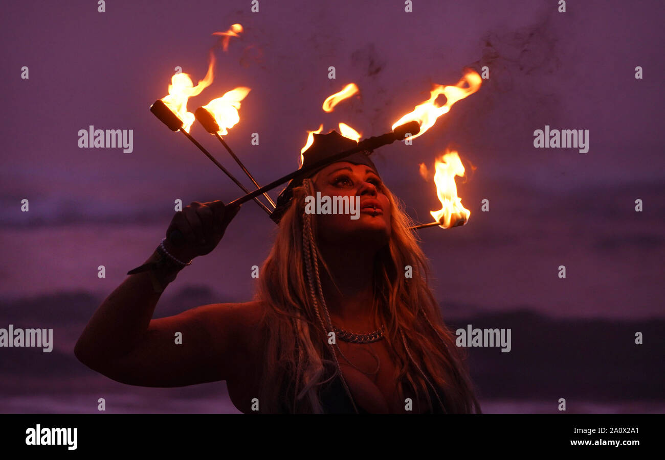 Fire performer Penella Bee performs before people take part in the ...