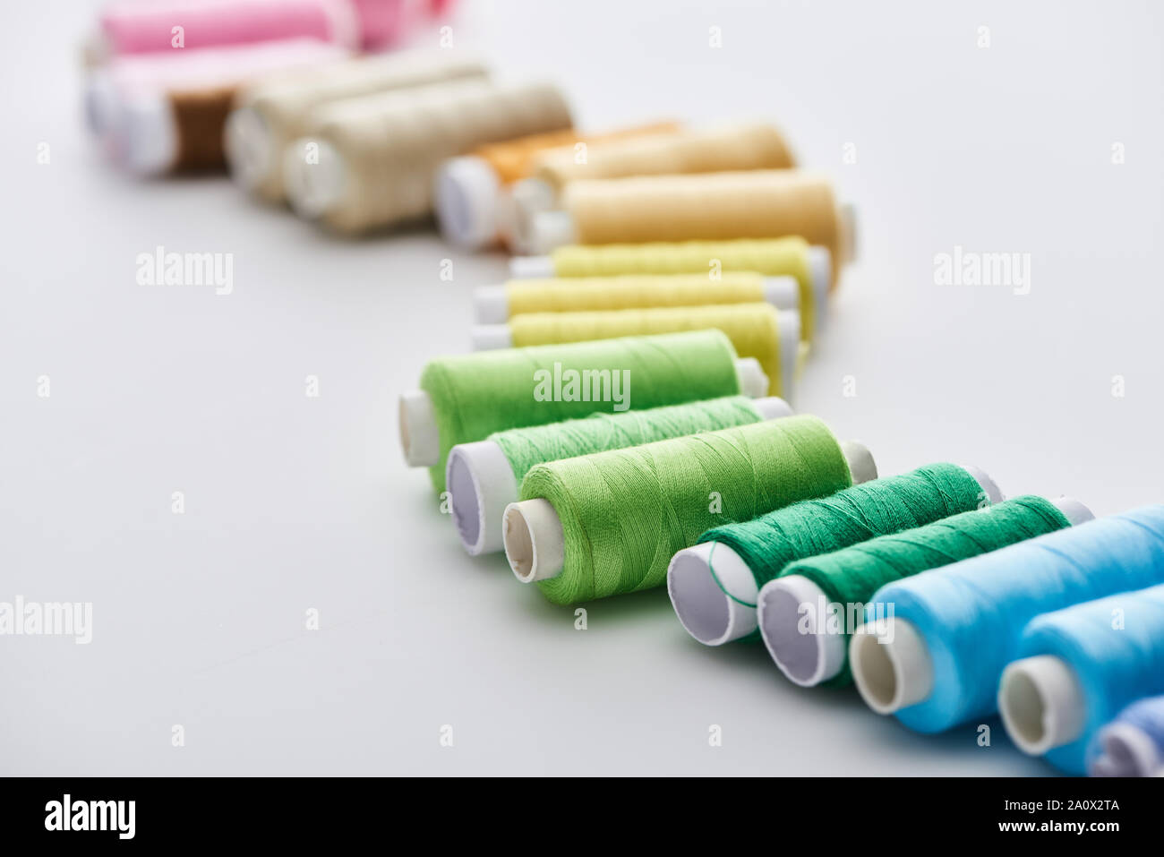 selective focus of bright and colorful threads on white background ...