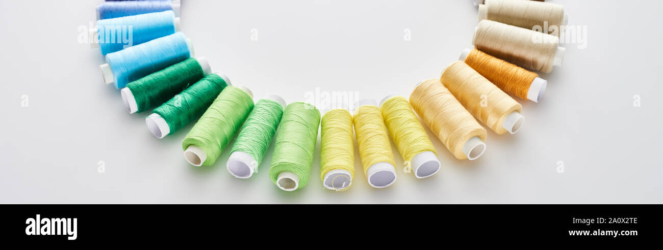panoramic shot of bright and colorful threads on white background Stock ...