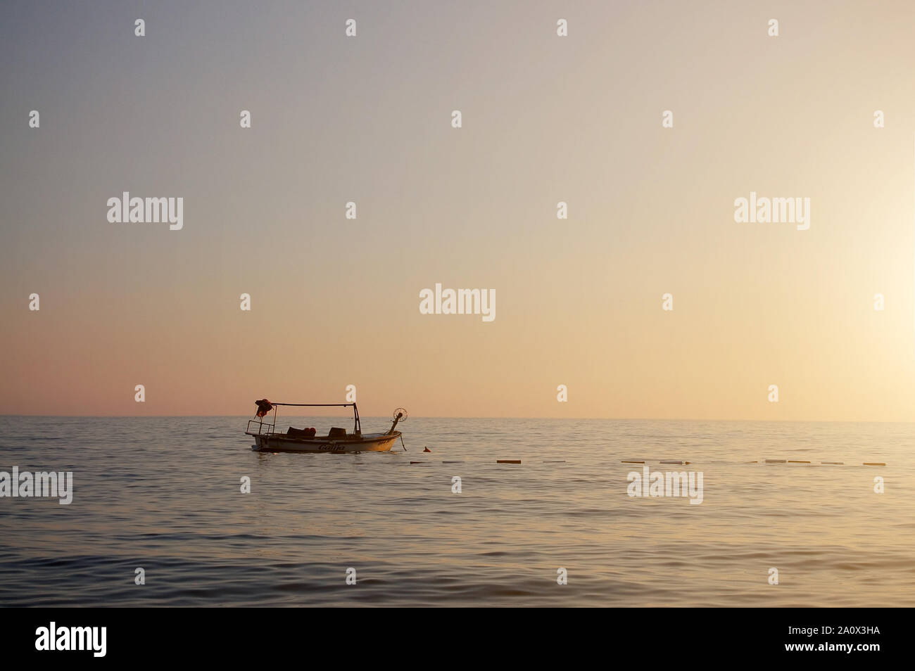 Small fishing boat anchored in the sea Stock Photo - Alamy