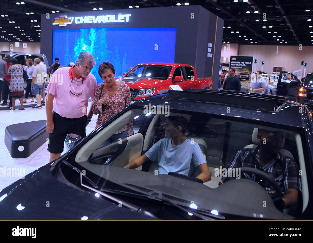 People sit inside a Chevrolet at the Central Florida International Auto ...