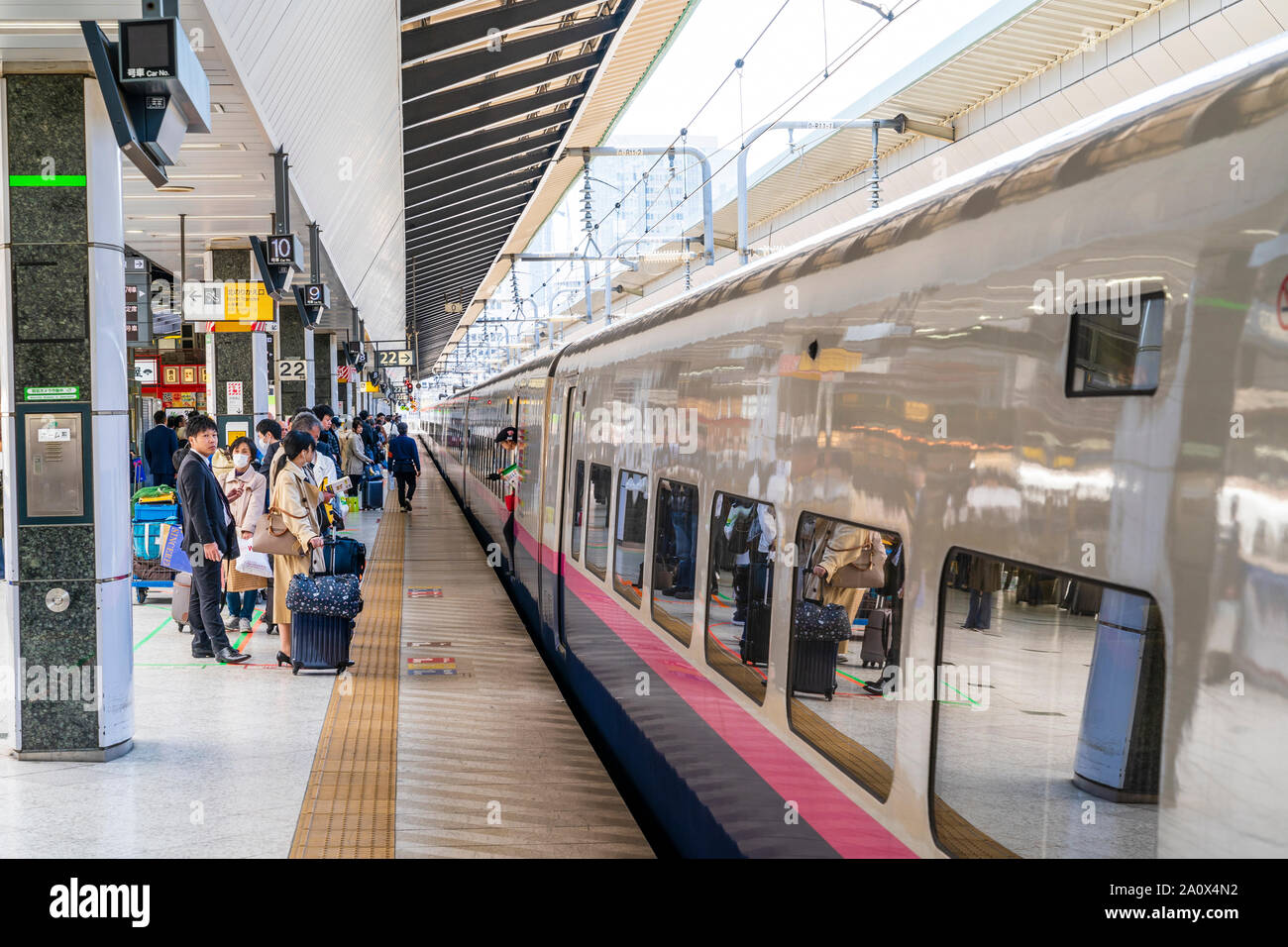 Japan. Tokyo station. View along platform of people waiting with an E2 ...