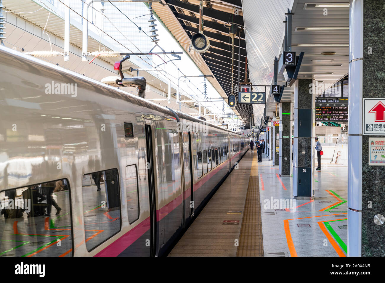 Japan. Tokyo station. View along platform of people waiting with an E2 ...