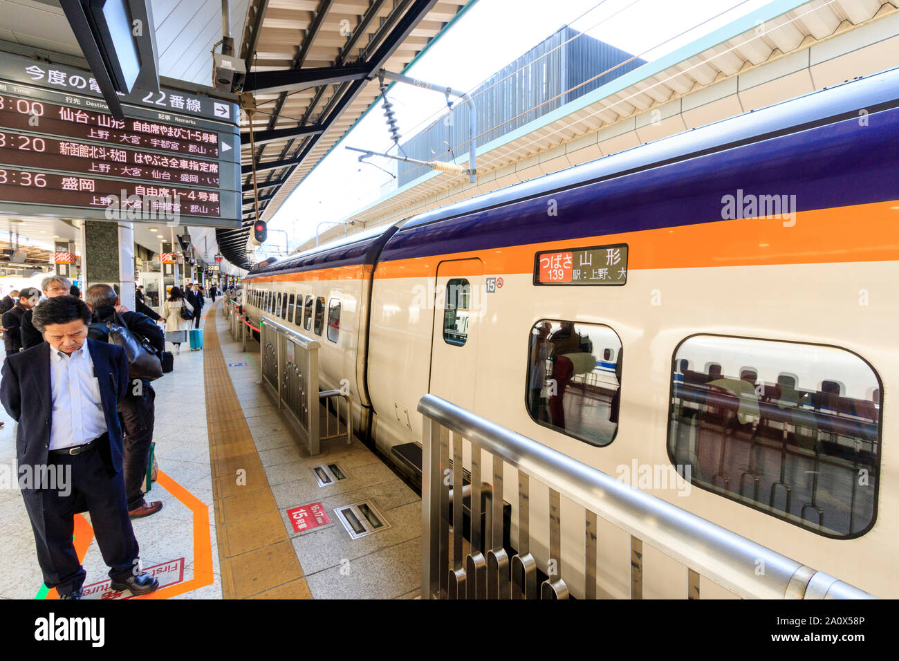Tokyo shinkansen, bullet train, station. People on platform as a ...