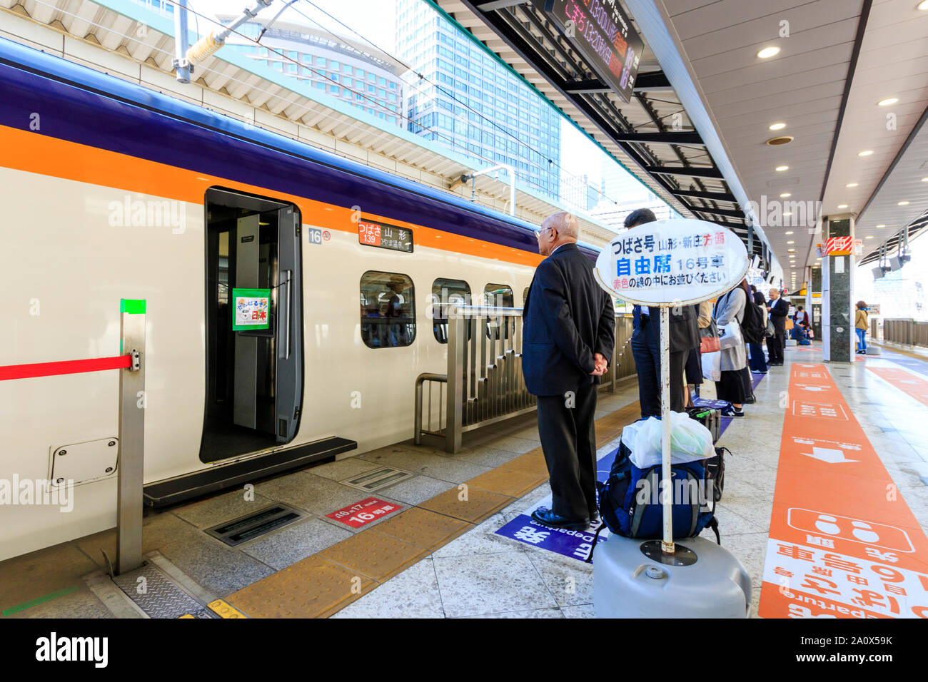 Tokyo shinkansen, bullet train, station. People waiting in line while a ...