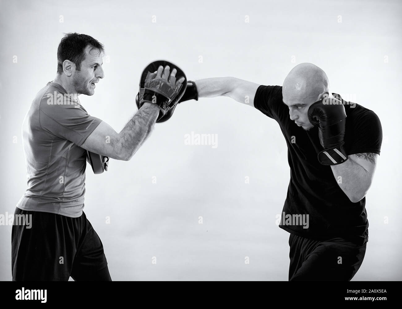 Boxer and his coach hitting mitts, black and white image Stock Photo ...