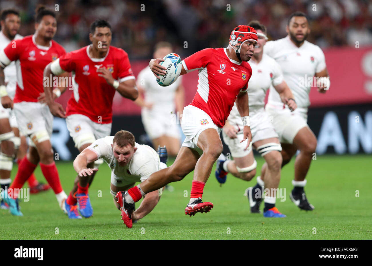 Tonga's Siale Piutau (right) is challenged by England's Sam Underhill ...