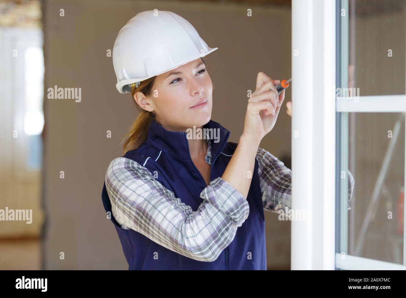 female window fitter using screwdriver Stock Photo - Alamy
