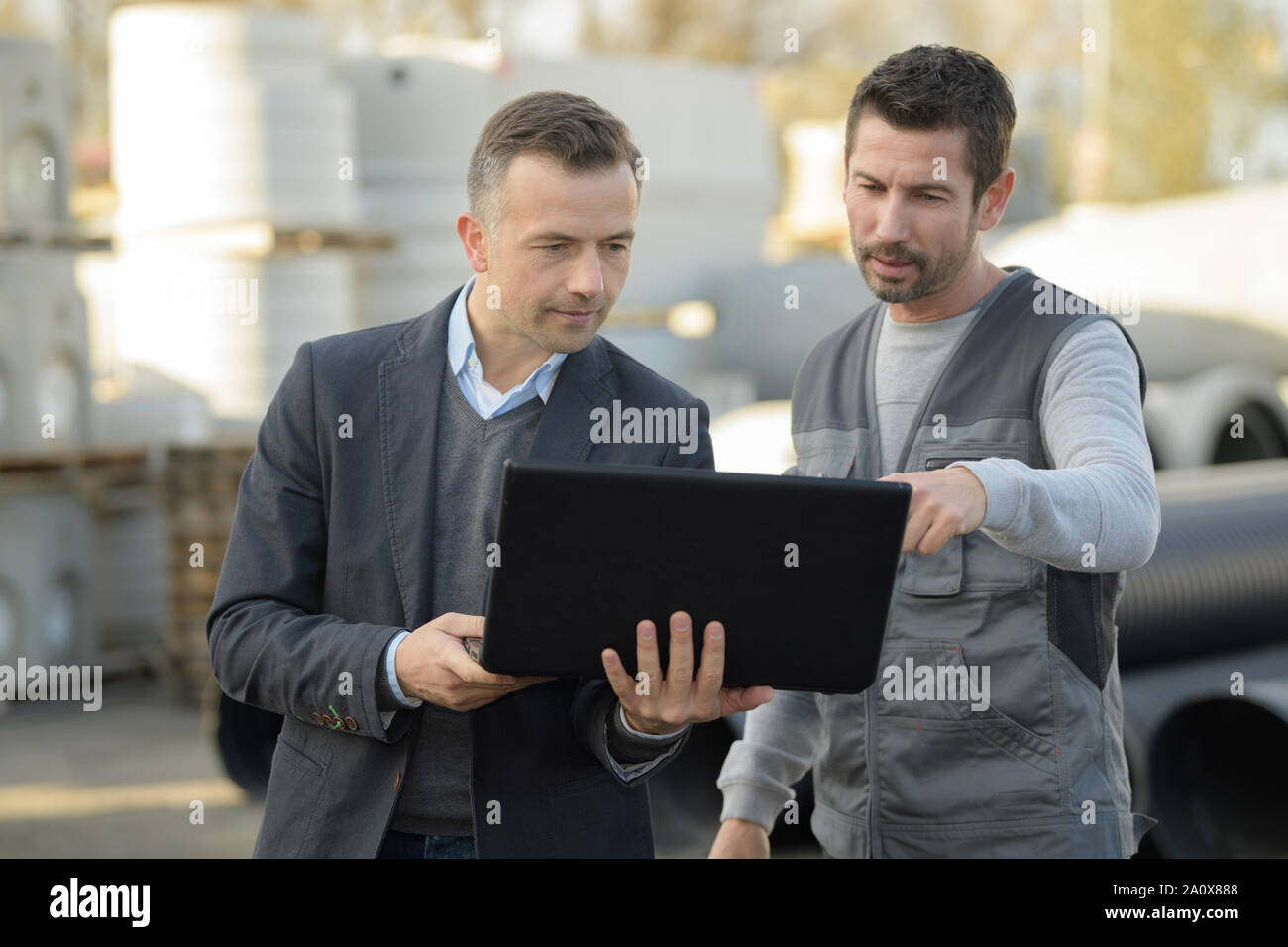 constructor and manager working on modern tablet outside renovated ...