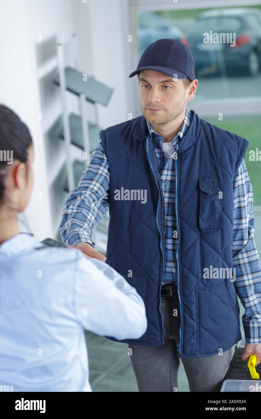 tradesman shaking hands with lady in business premises Stock Photo - Alamy