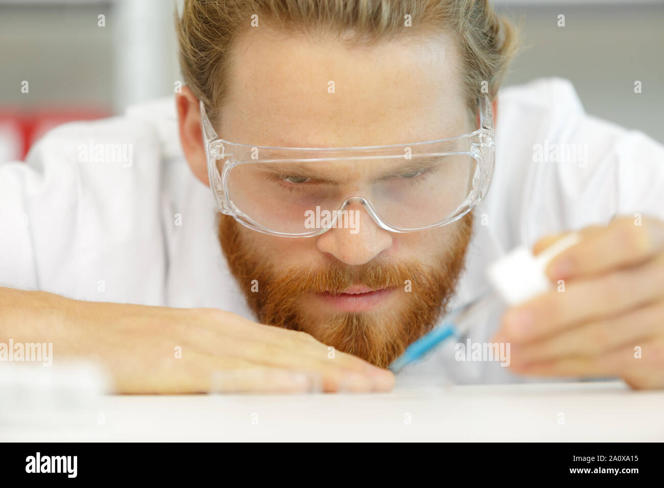 lab worker using pipette to add blue liquid in test-tube Stock Photo ...