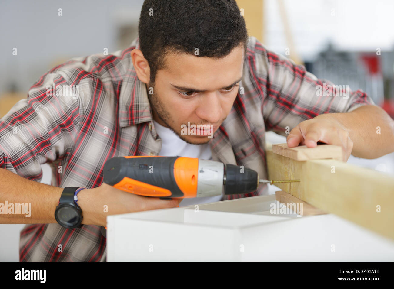 young man drilling wood with drill at home Stock Photo - Alamy