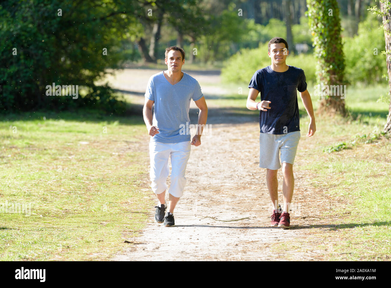 two young men running in the park Stock Photo - Alamy