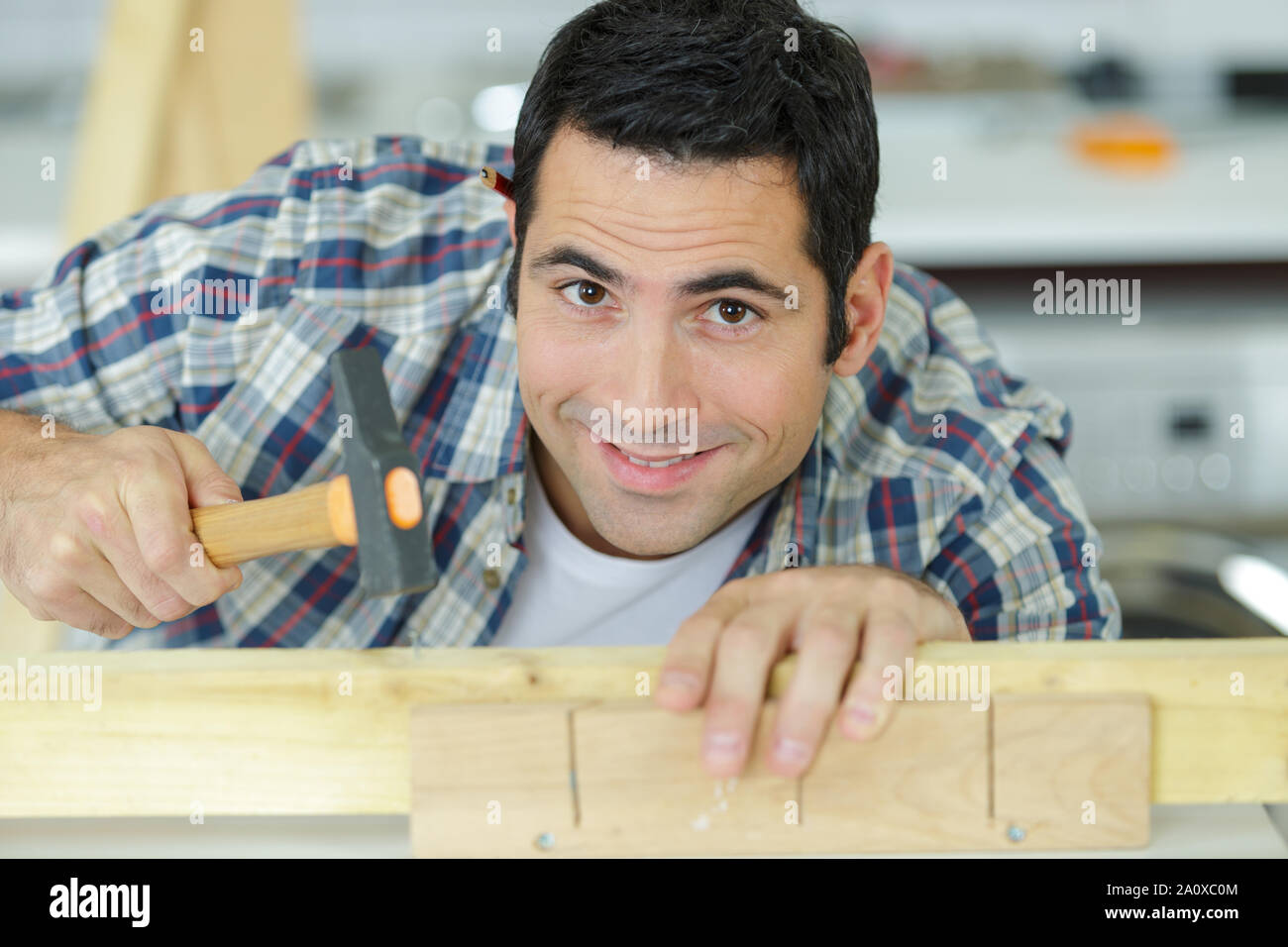 happy man using hammer and nail spike Stock Photo - Alamy