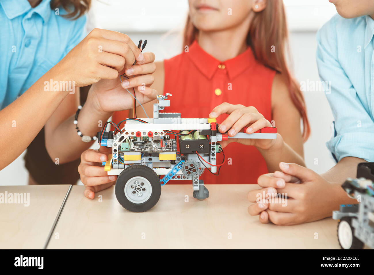 Robotics. Children having class sitting making robots wires connection ...
