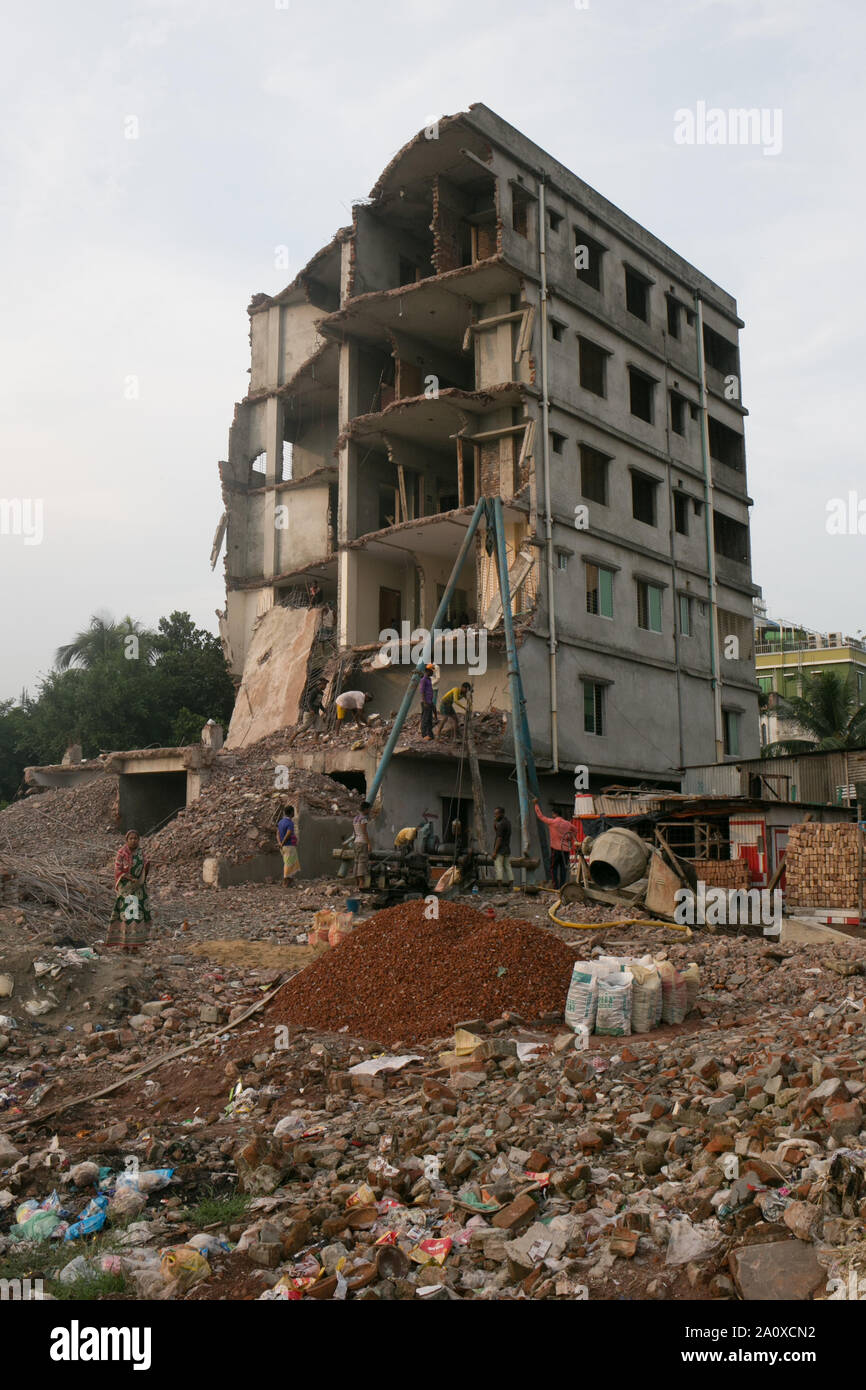 Labors seen working in front of a broken building in the bank of ...