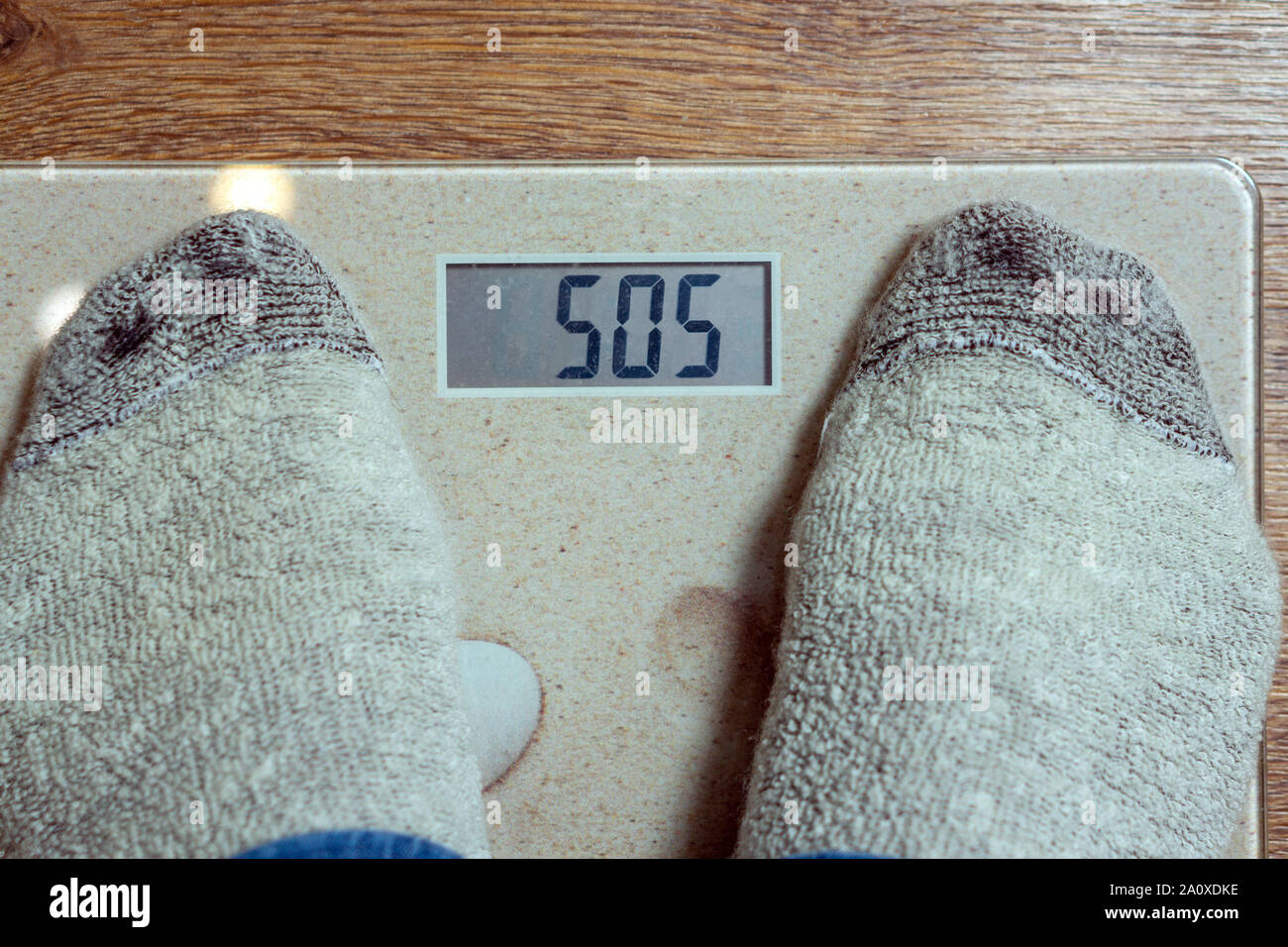Men's feet on the scales. The inscription SOS on the scales. Close-up ...