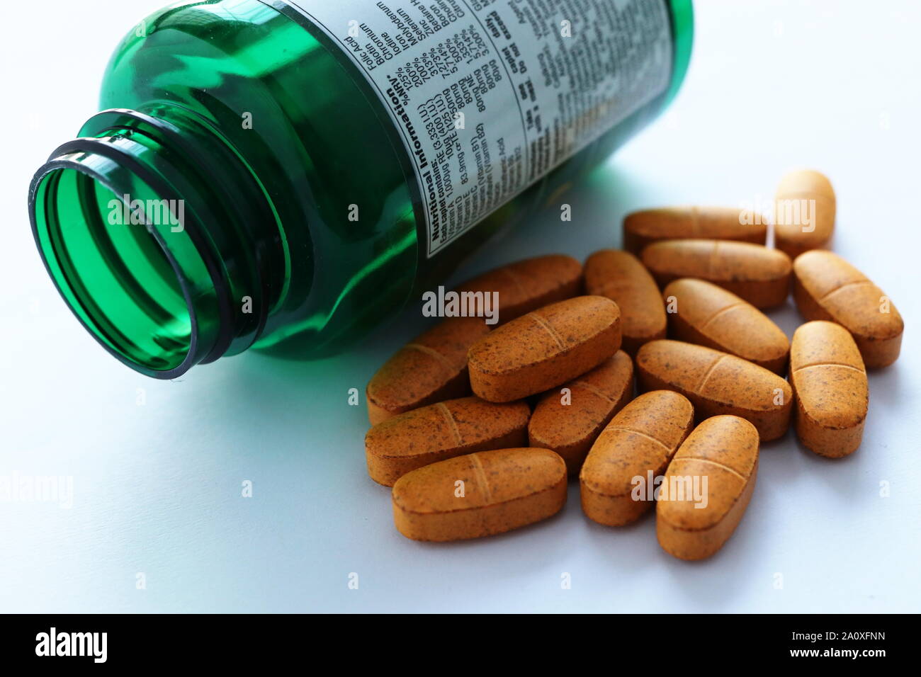 Multivitamin tablets and green container bottle with label showing ...