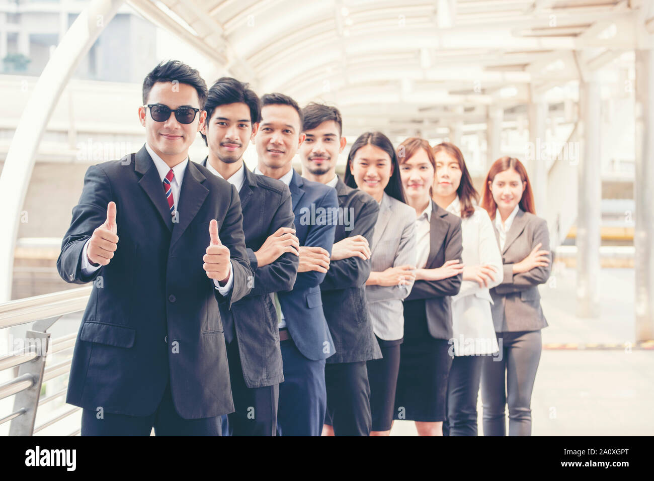 Business partners giving thumbs up after complete a deal to show ...