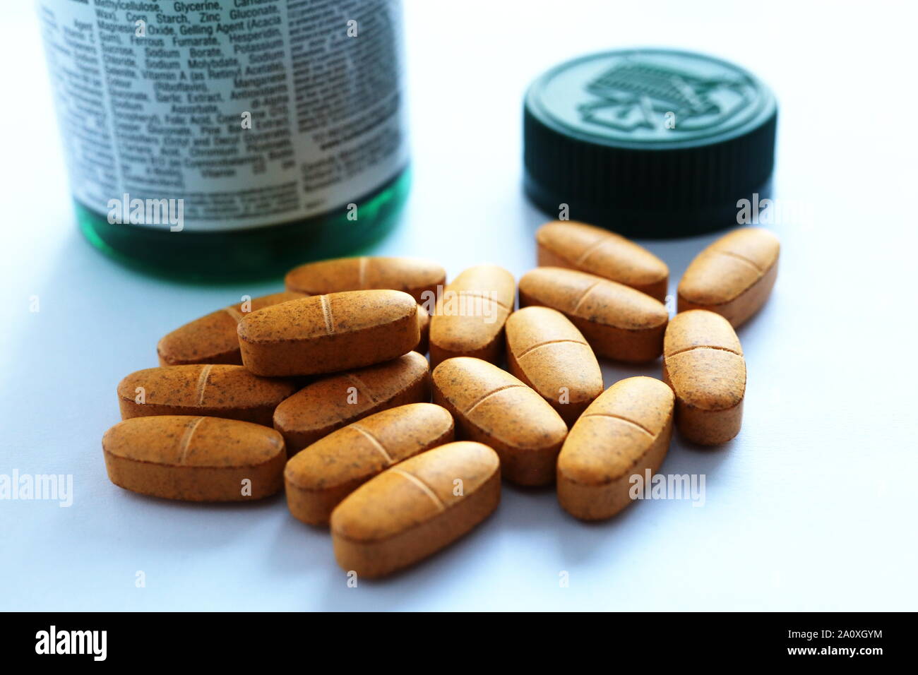 Multivitamin tablets and green container bottle with label showing ...