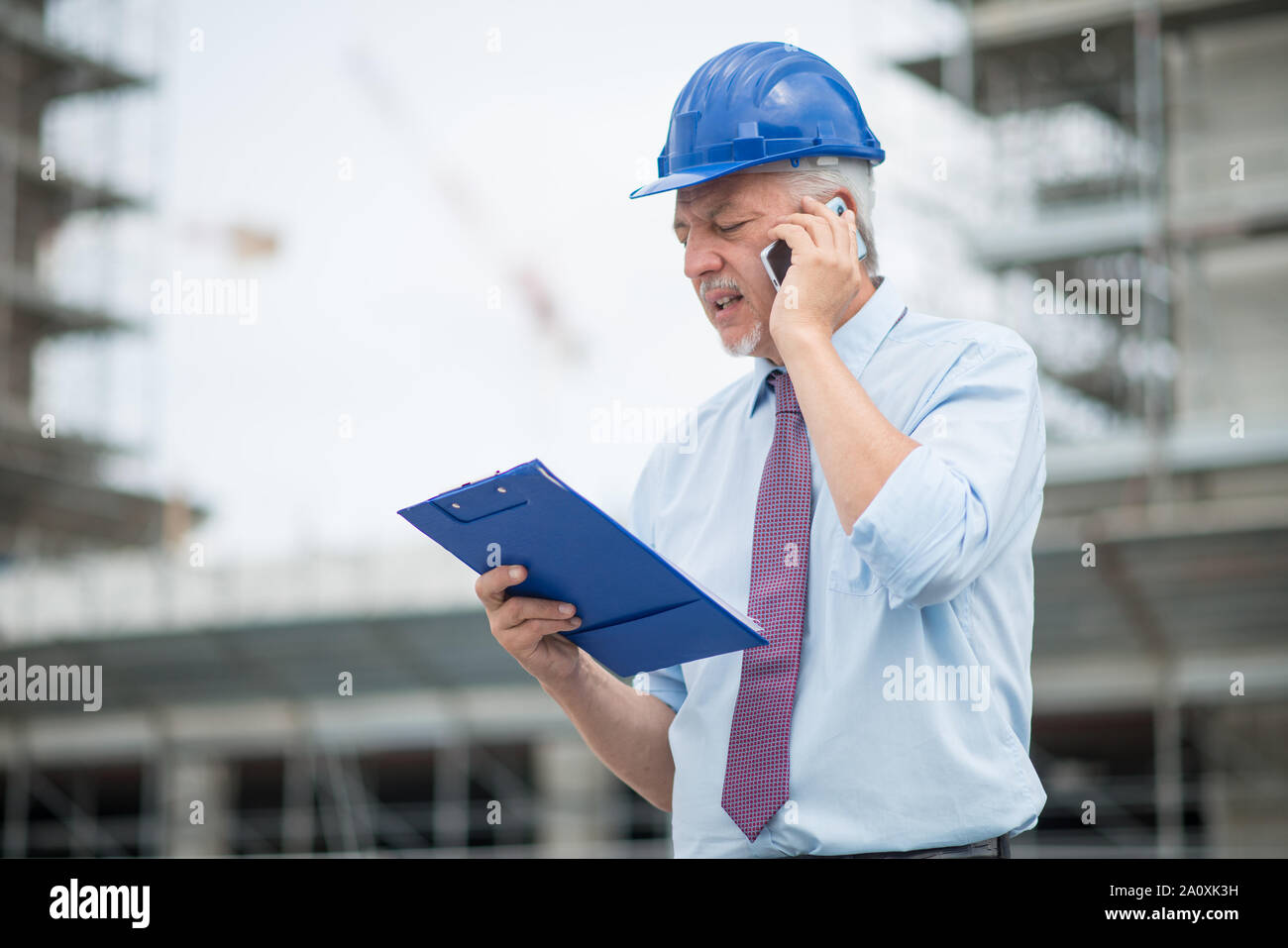 Architect manager talking on the cellphone in front of construction ...