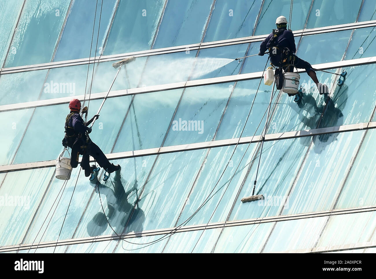 Kuwait City, Kuwait. 22nd Sep, 2019. Window cleaners work outside a ...