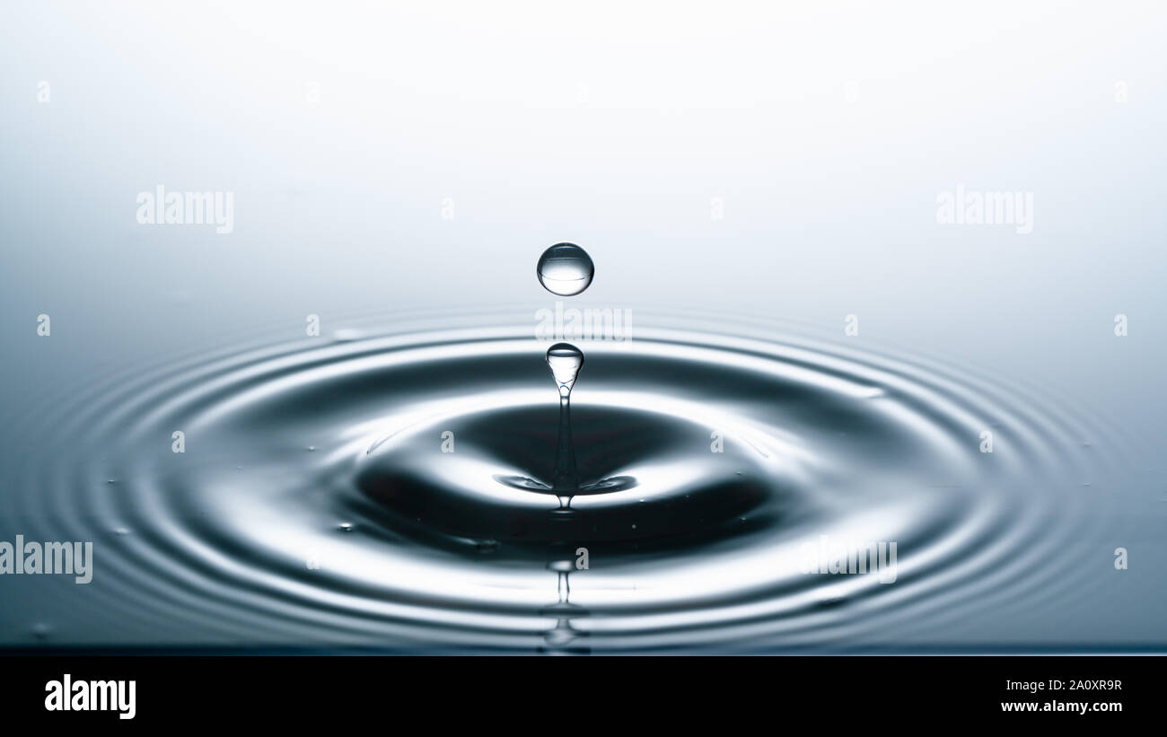 Close-up of a water drop falling on water surface Stock Photo - Alamy