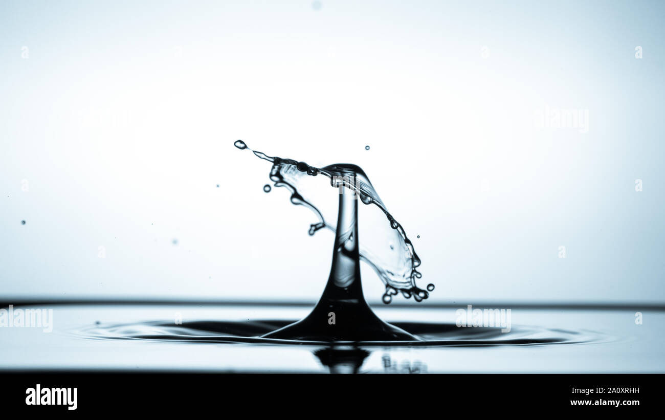 Close-up of a water drop falling on water surface Stock Photo - Alamy