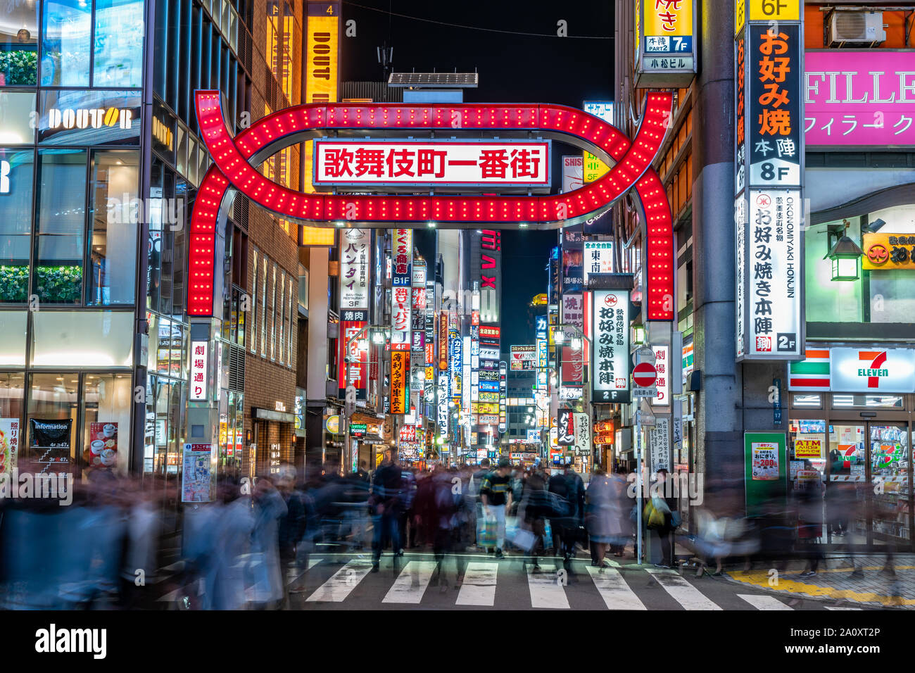 Motion blured people walking through the entrance of Kabukicho ...