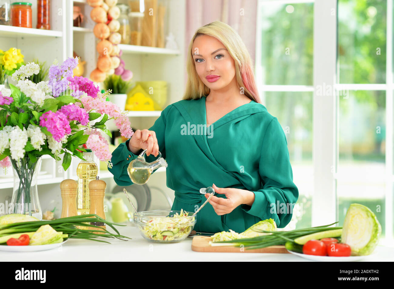 Portrait of beautiful young woman cooking in kitchen Stock Photo - Alamy