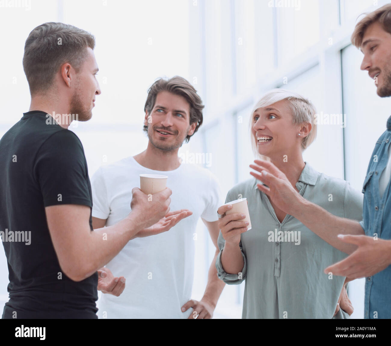 group of co-workers are discussing something in the office corridor ...