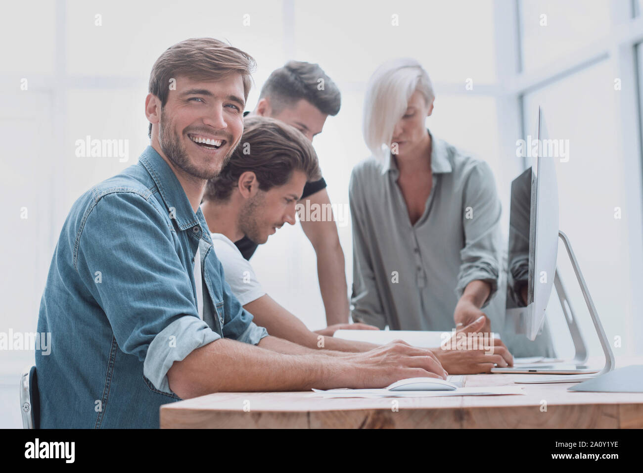 smiling employee sitting at the office Desk Stock Photo - Alamy