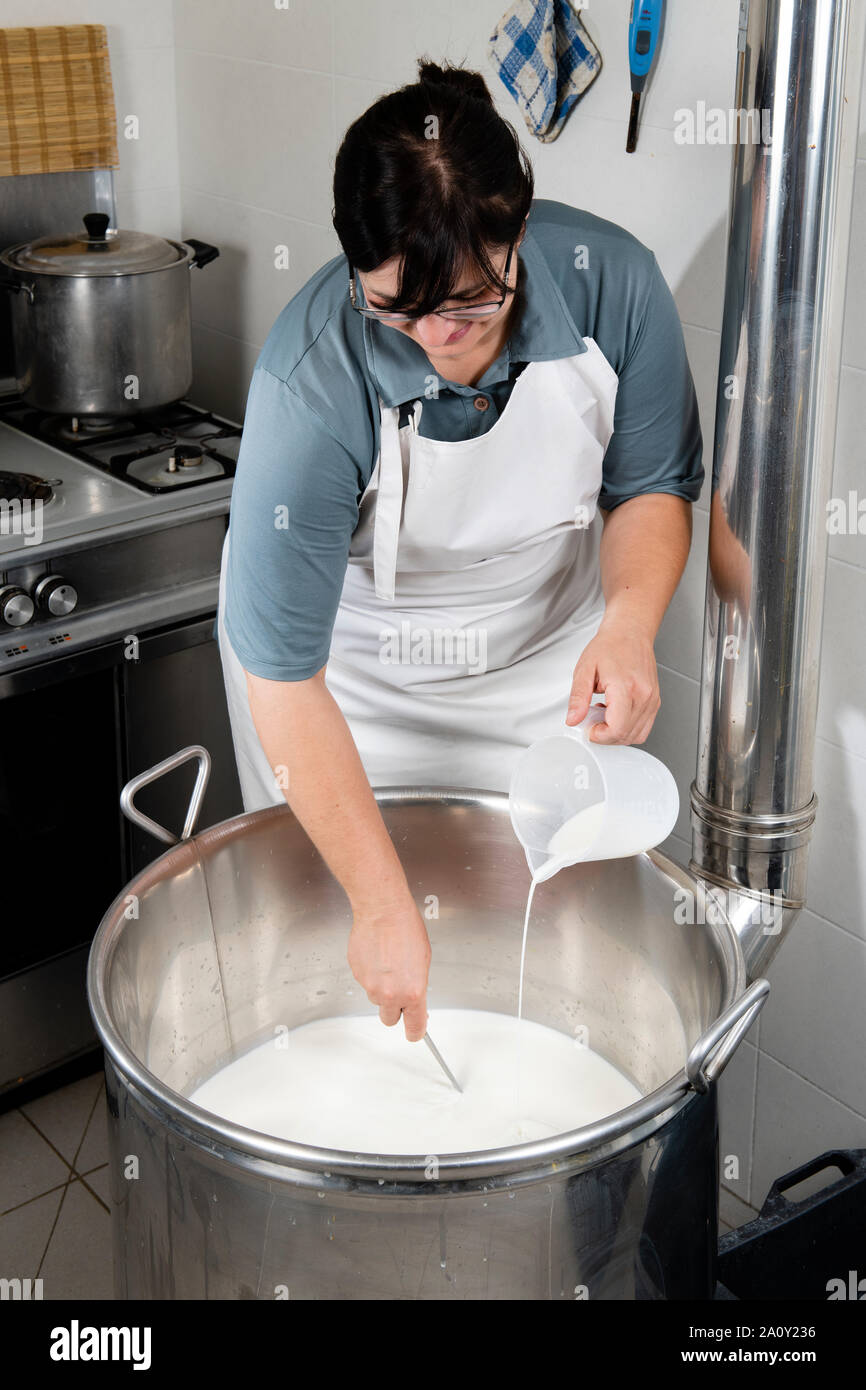 Cheesemaker pours the rennet with a ladle and a jug Stock Photo - Alamy