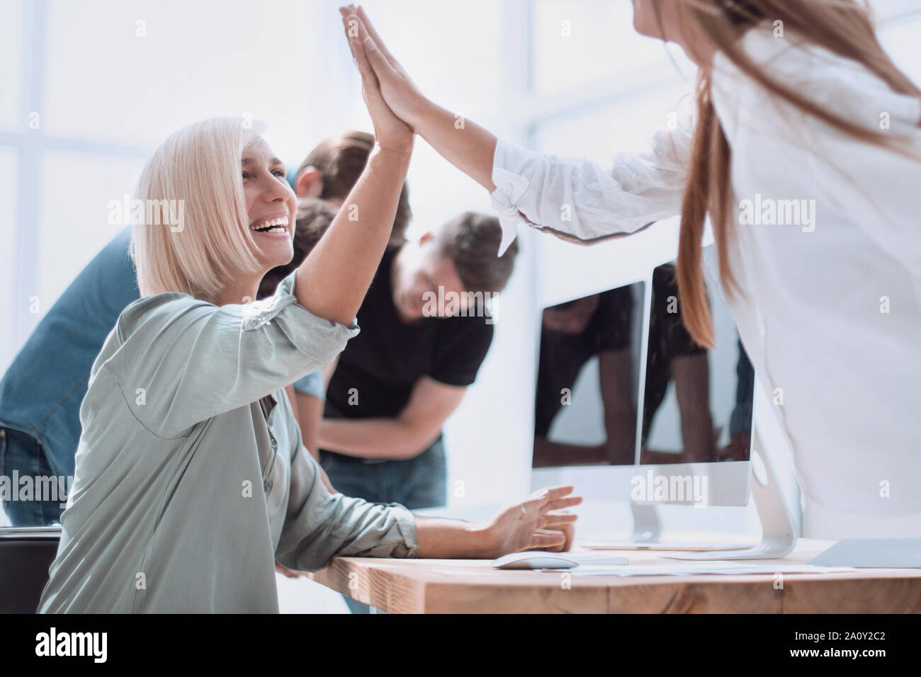 Manager and the young employee are giving each other a high five Stock ...