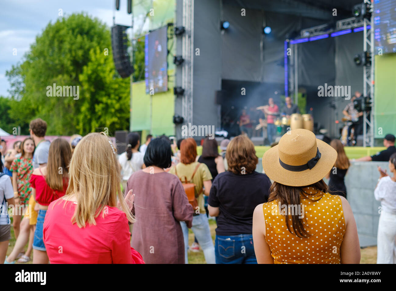 Girls friends watching concert at open air music festival, rear view ...