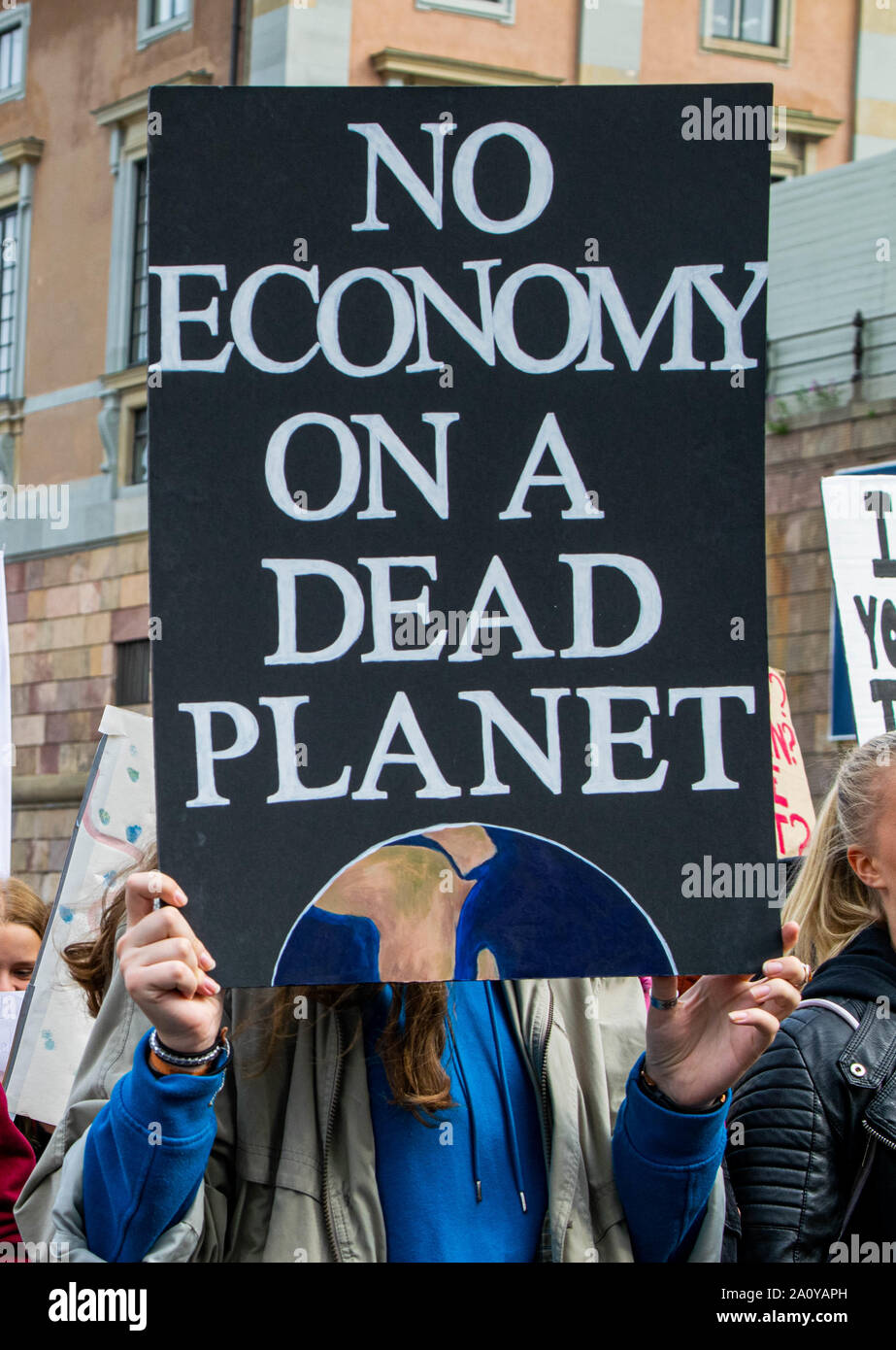 Young person holding up climate change protest banner while ...