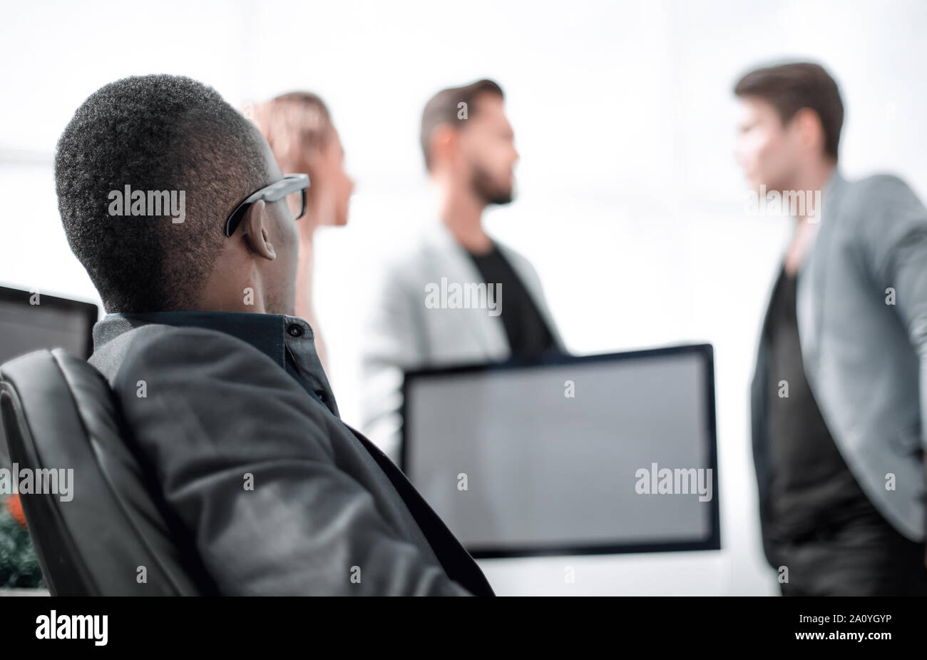rear view.businessman sitting at his Desk Stock Photo - Alamy